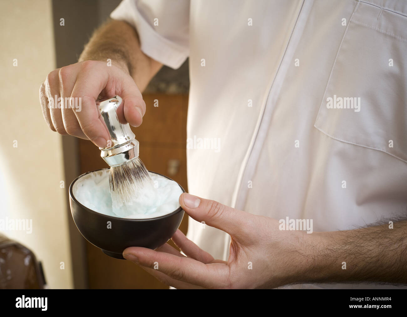 Mid section view of a man s hand mixing shaving cream with a brush in a ...