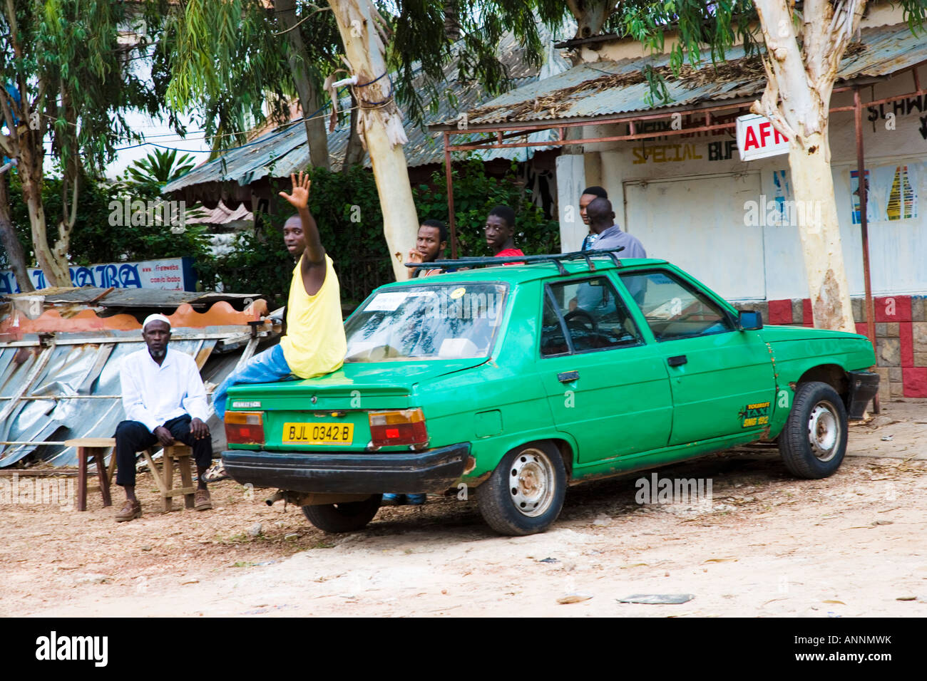 Gambian men waving and chatting - a typical village scene in the Gambia ...