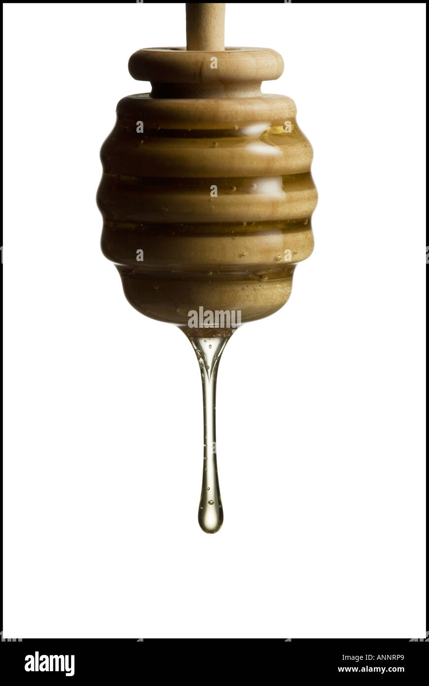 Drop of honey falling from a honey dipper Stock Photo - Alamy