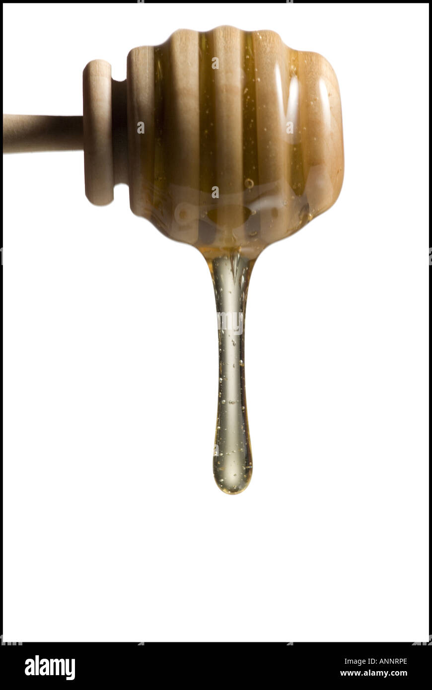Drop of honey falling from a honey dipper Stock Photo - Alamy