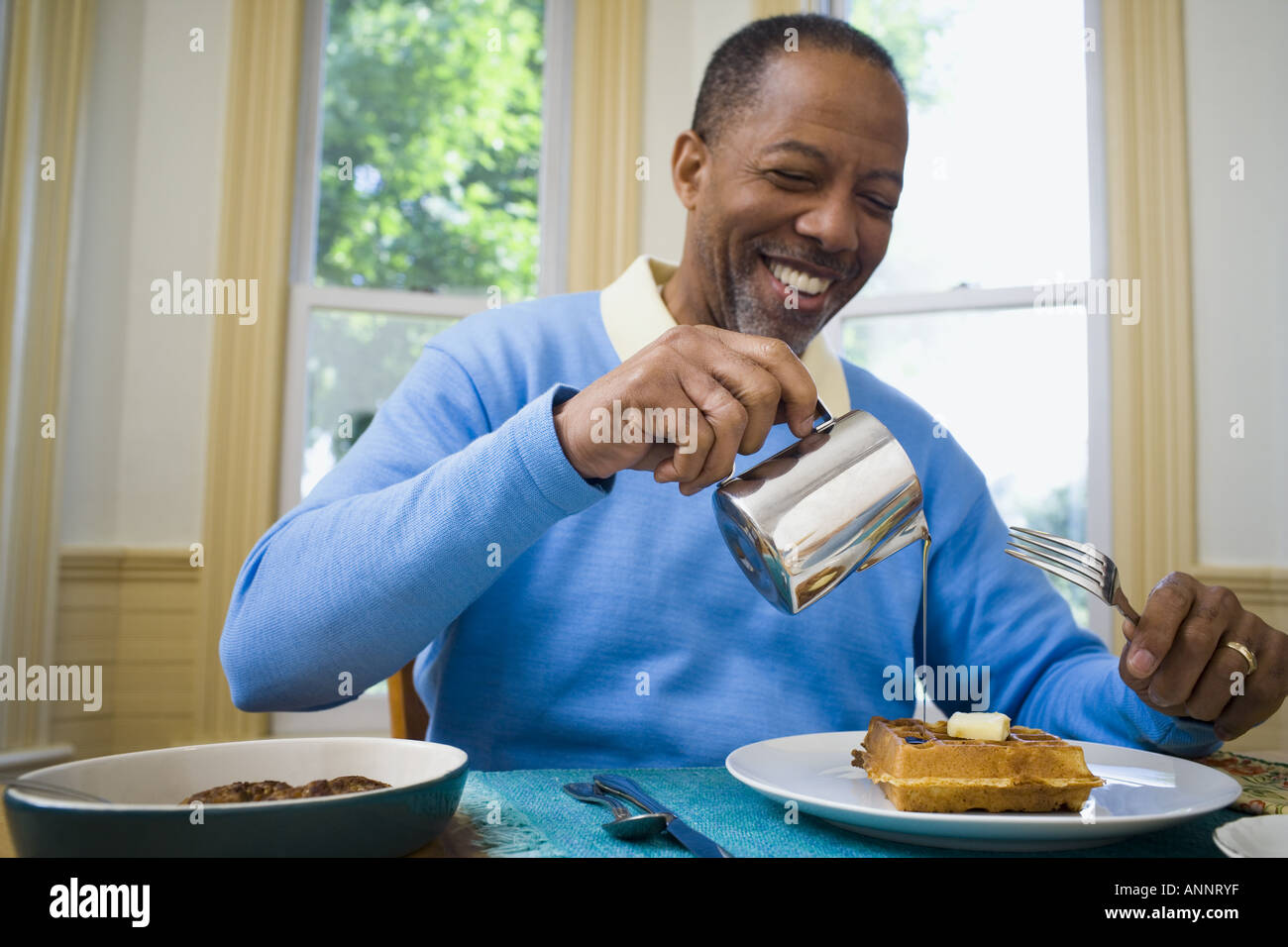 Close up of a senior man pouring syrup on his waffle Stock Photo - Alamy