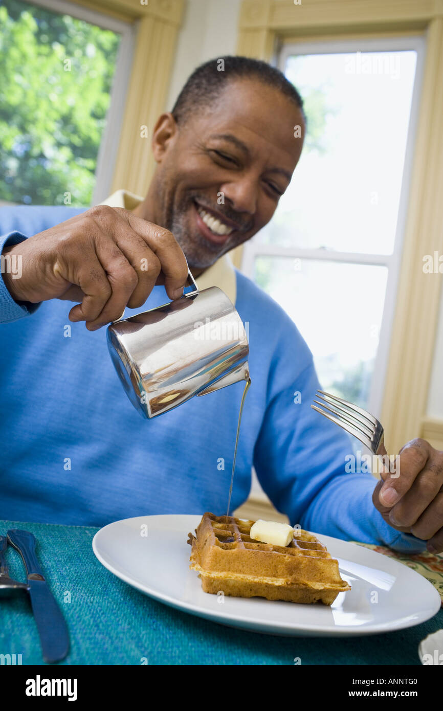 Close up of a senior man pouring syrup on his waffle Stock Photo - Alamy