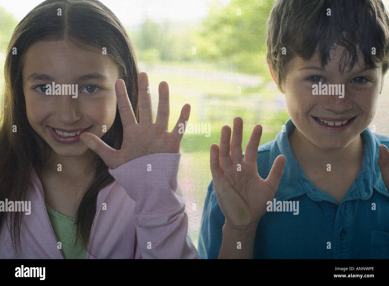 Portrait of a boy and a girl peeping through a window Stock Photo - Alamy