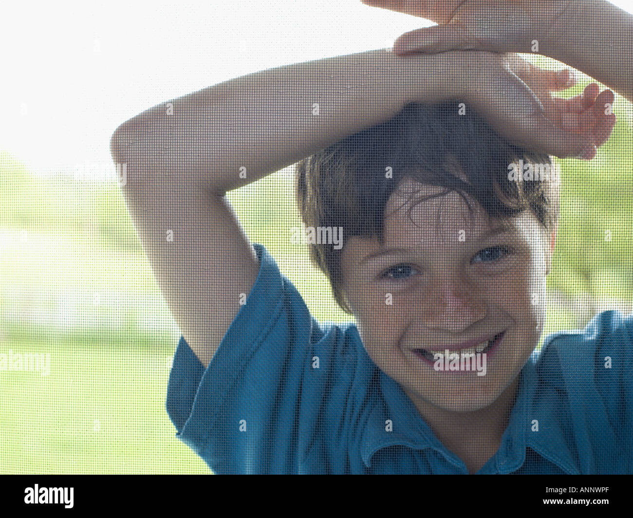 Portrait of a boy peeping through a window Stock Photo - Alamy