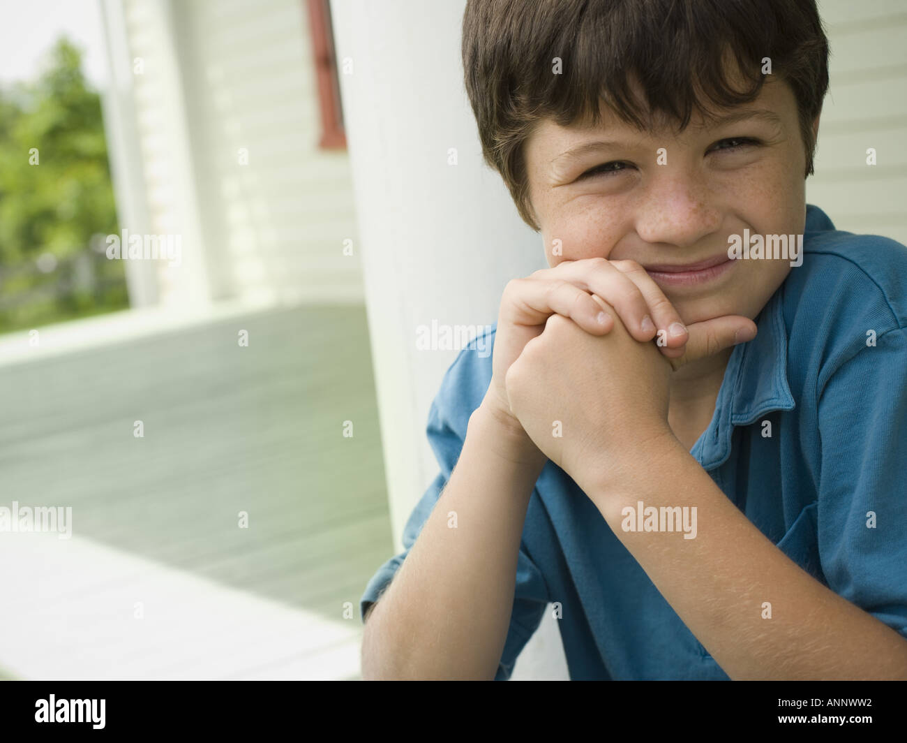 Portrait of a boy with his hands on his chin Stock Photo - Alamy