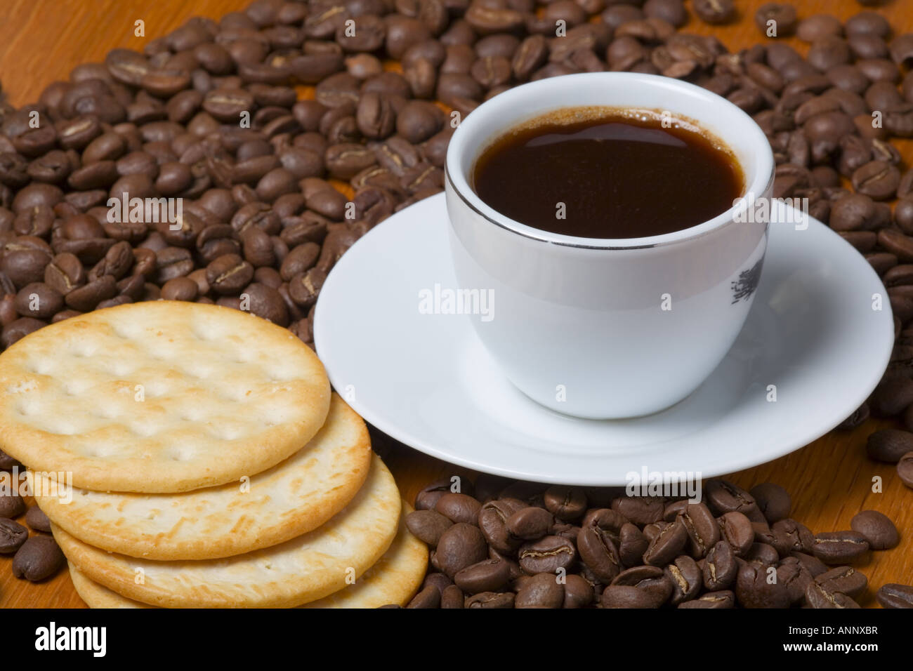 White cup of coffee with beans and crackers Stock Photo - Alamy