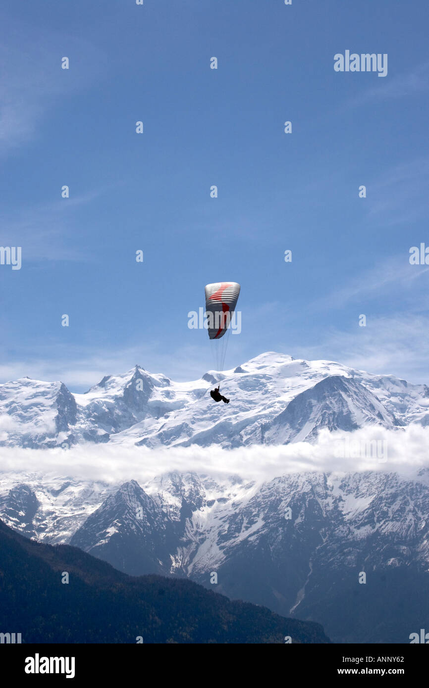 Paragliding pilot flying grey and red paraglider with Mont blanc and ...