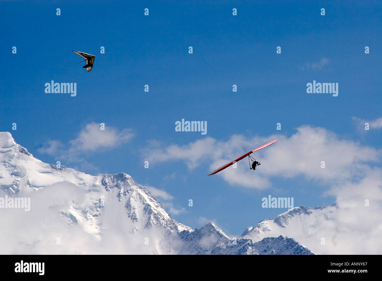 Hang gliding pilots flying hang gliders in snowy mountains of French ...
