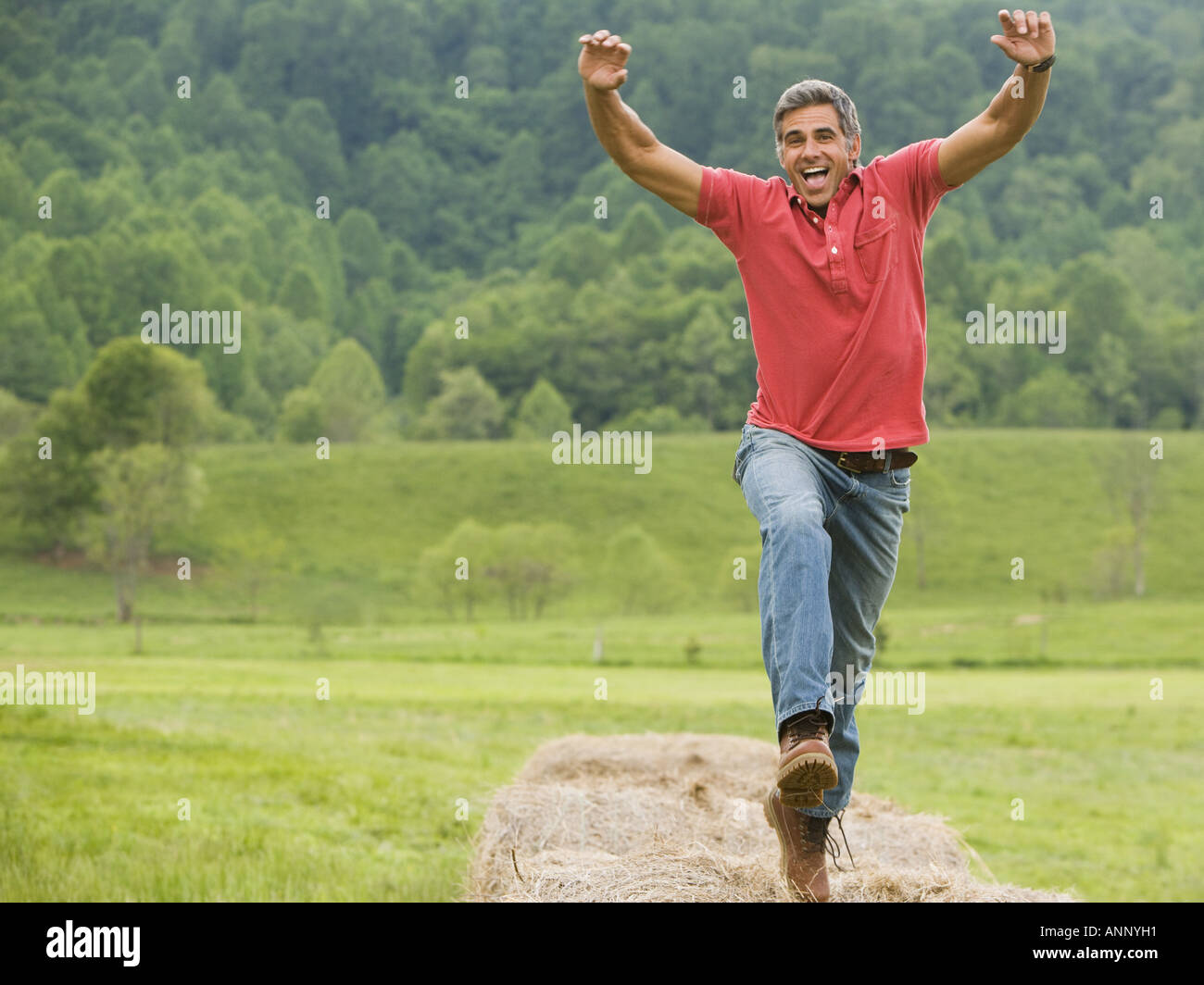 Portrait of a man jumping on a hay bale Stock Photo - Alamy