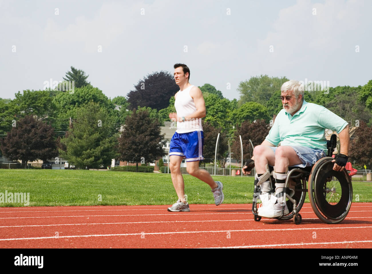 Young man racing with a handicapped senior man on the racetrack Stock ...