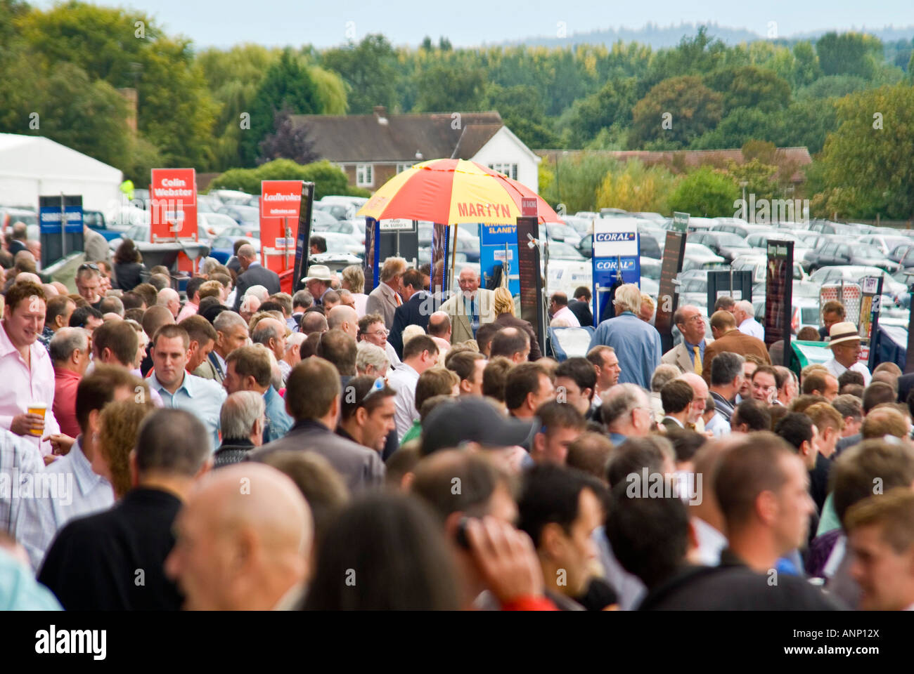 Horizontal aerial view across crowds of people queueing to place bets ...