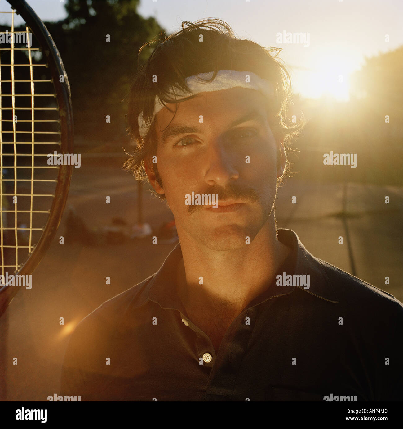 Portrait of a young man holding a tennis racket Stock Photo - Alamy