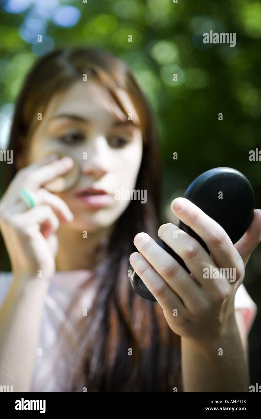 Teenage girl applying powder on her face Stock Photo - Alamy