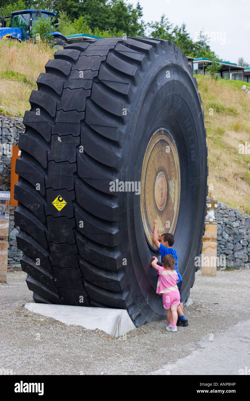 Young boy and girl standing next to a gigantic tyre Stock Photo - Alamy