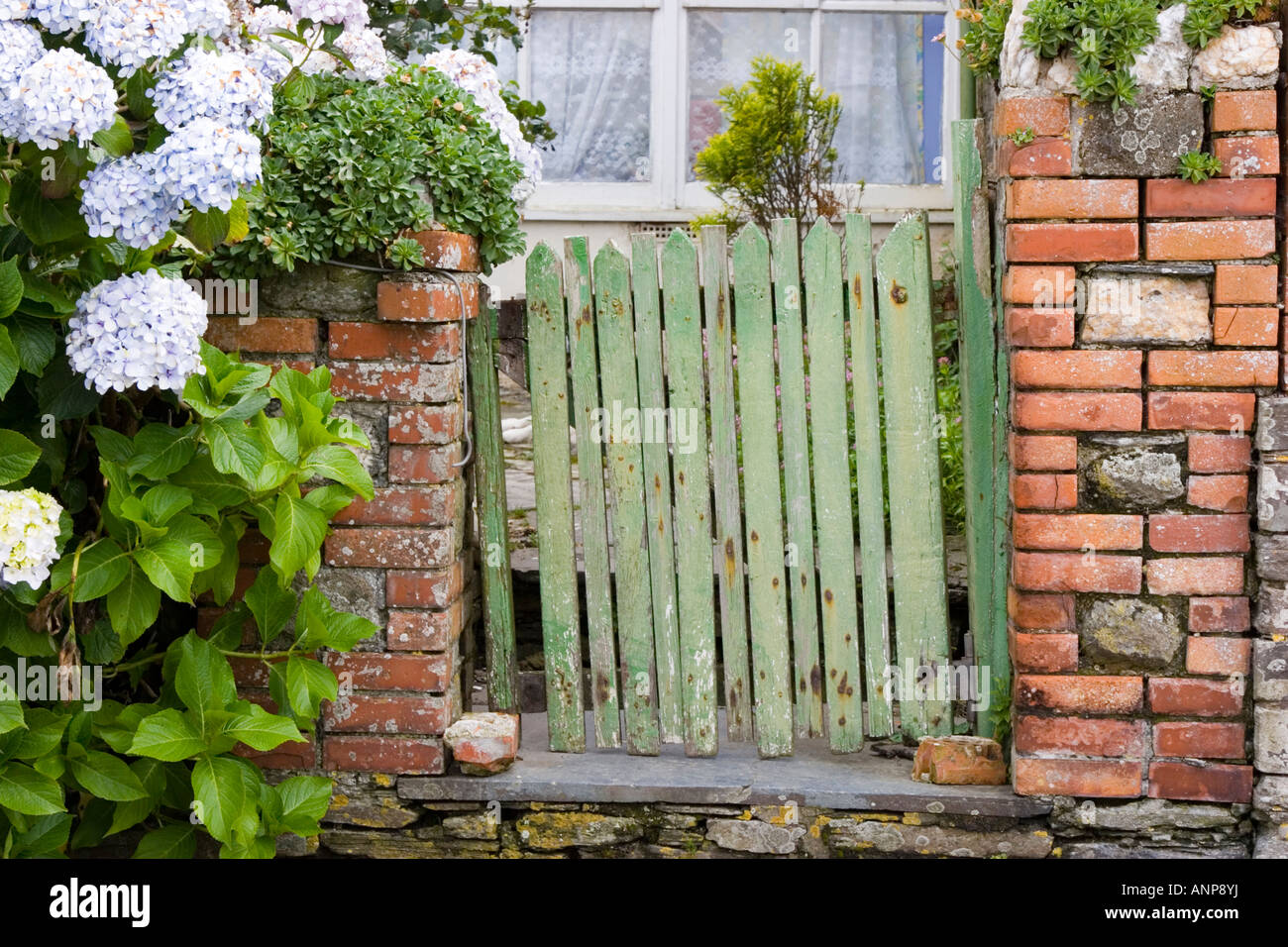 A garden gate a red brick boundary wall having seen better days Stock ...