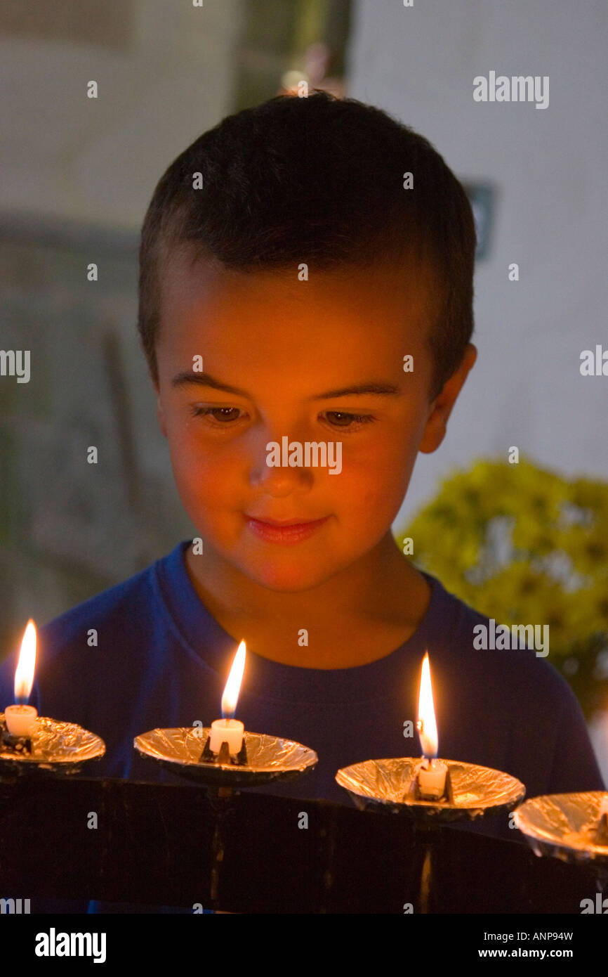 A small boy has lit a candle in a church Stock Photo - Alamy