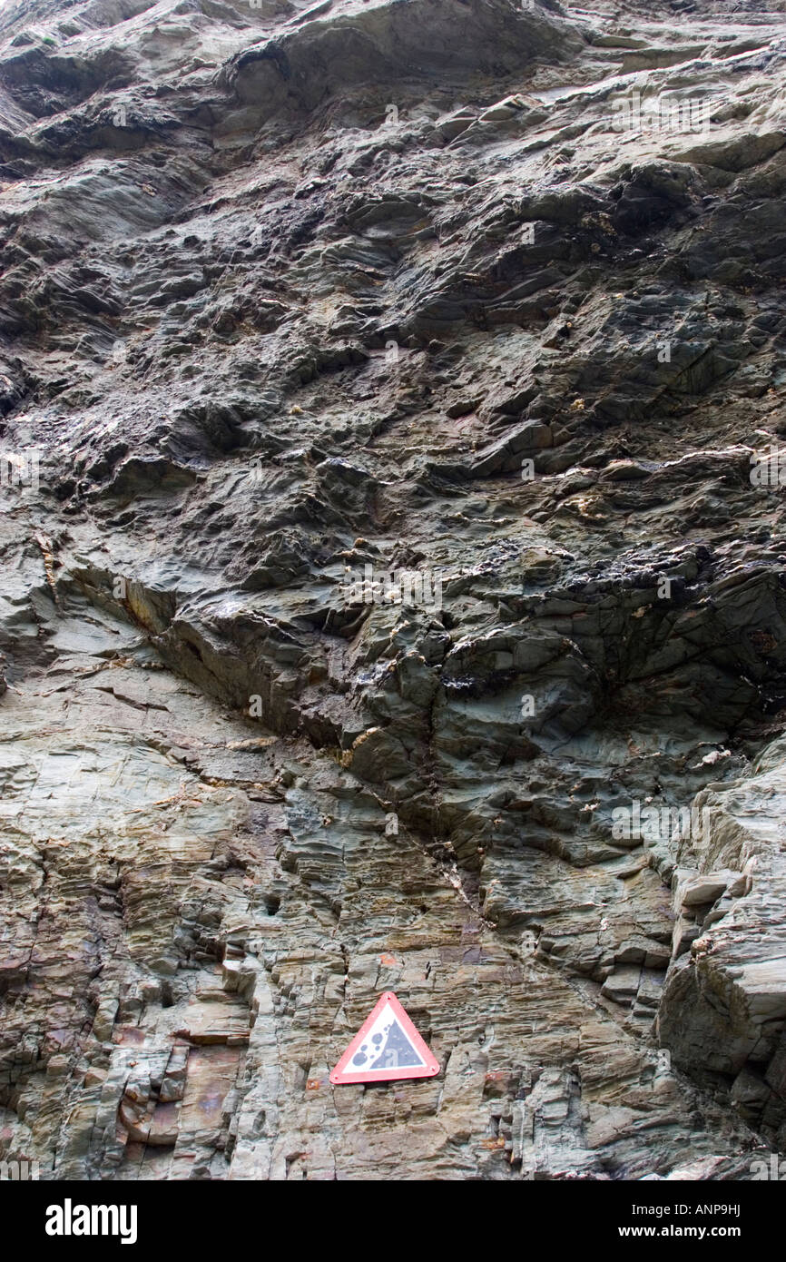 Sign attached to sheer cliff face warning of falling rocks Stock Photo ...