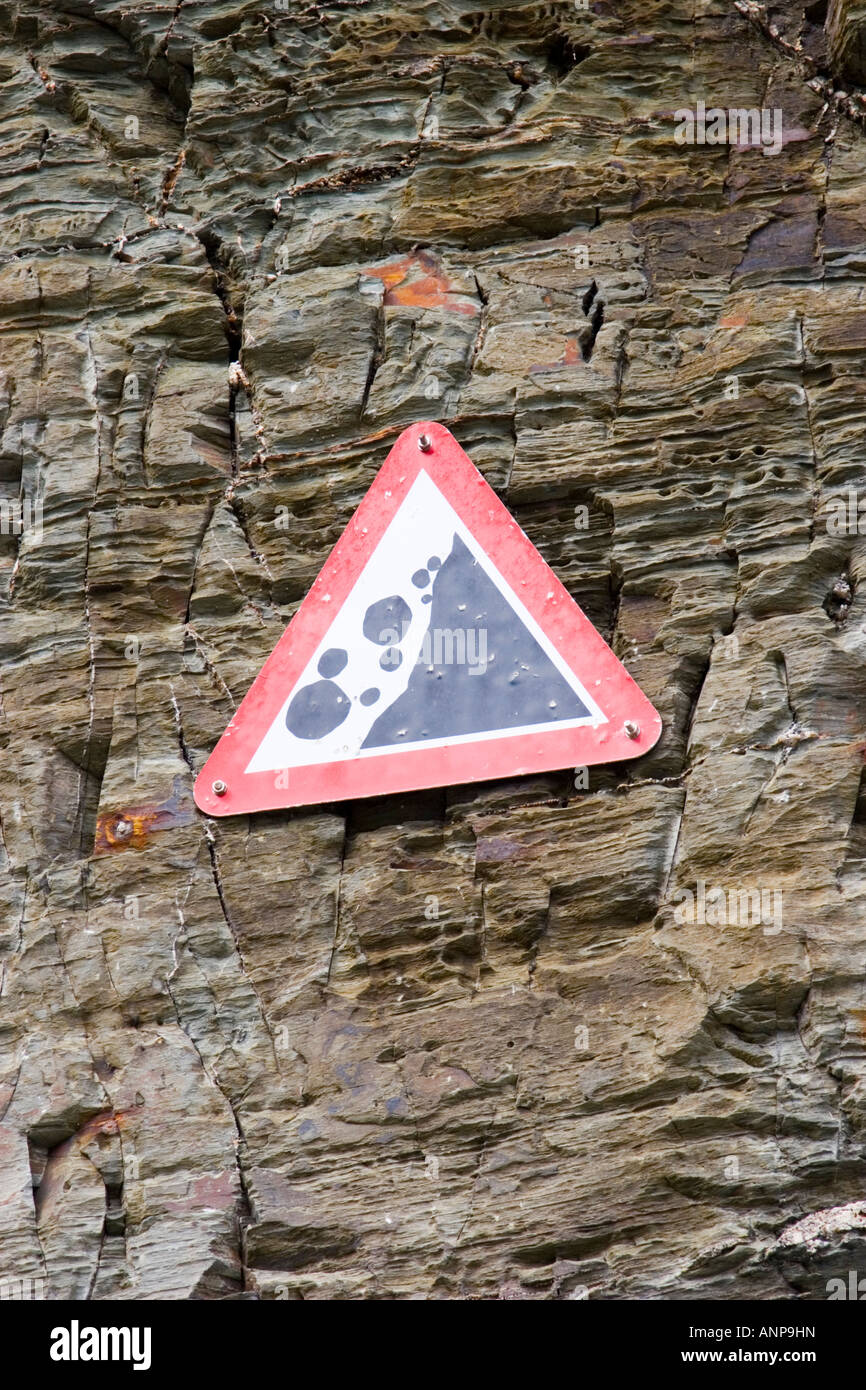 Sign attached to sheer cliff face warning of falling rocks Stock Photo ...