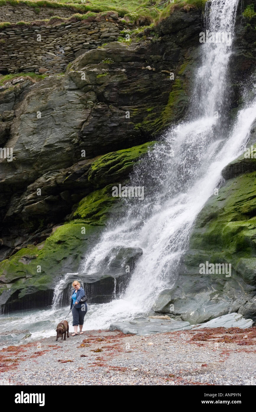 Waterfall cascading onto the beach underneath the ancient castle in ...