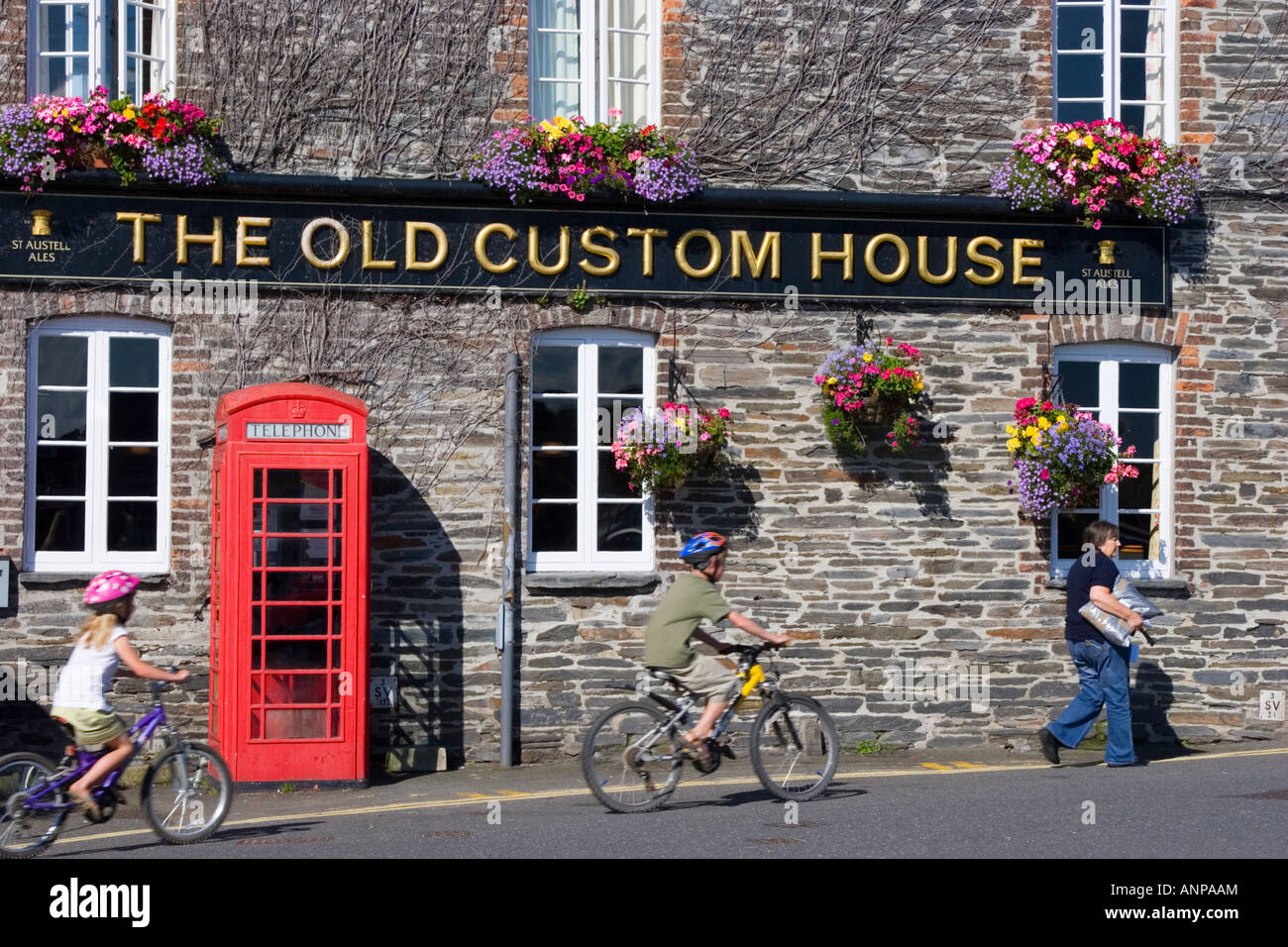 Cyclists riding past the Old Customs House pub in Padstow Stock Photo ...