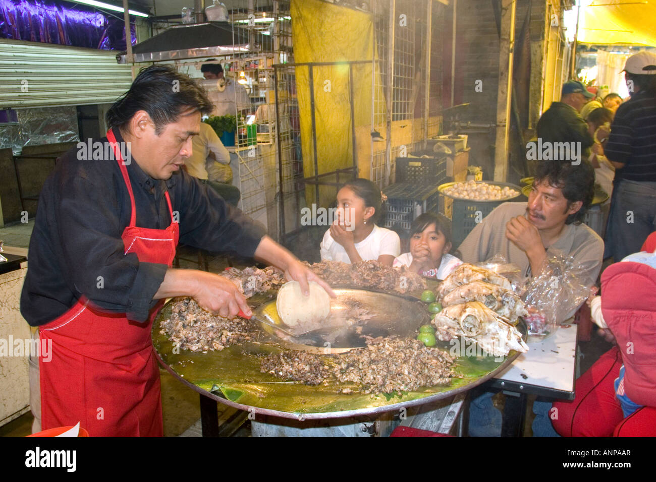 Vendor cooking cabeza tacos using a cazo at the Merced Market in Mexico ...
