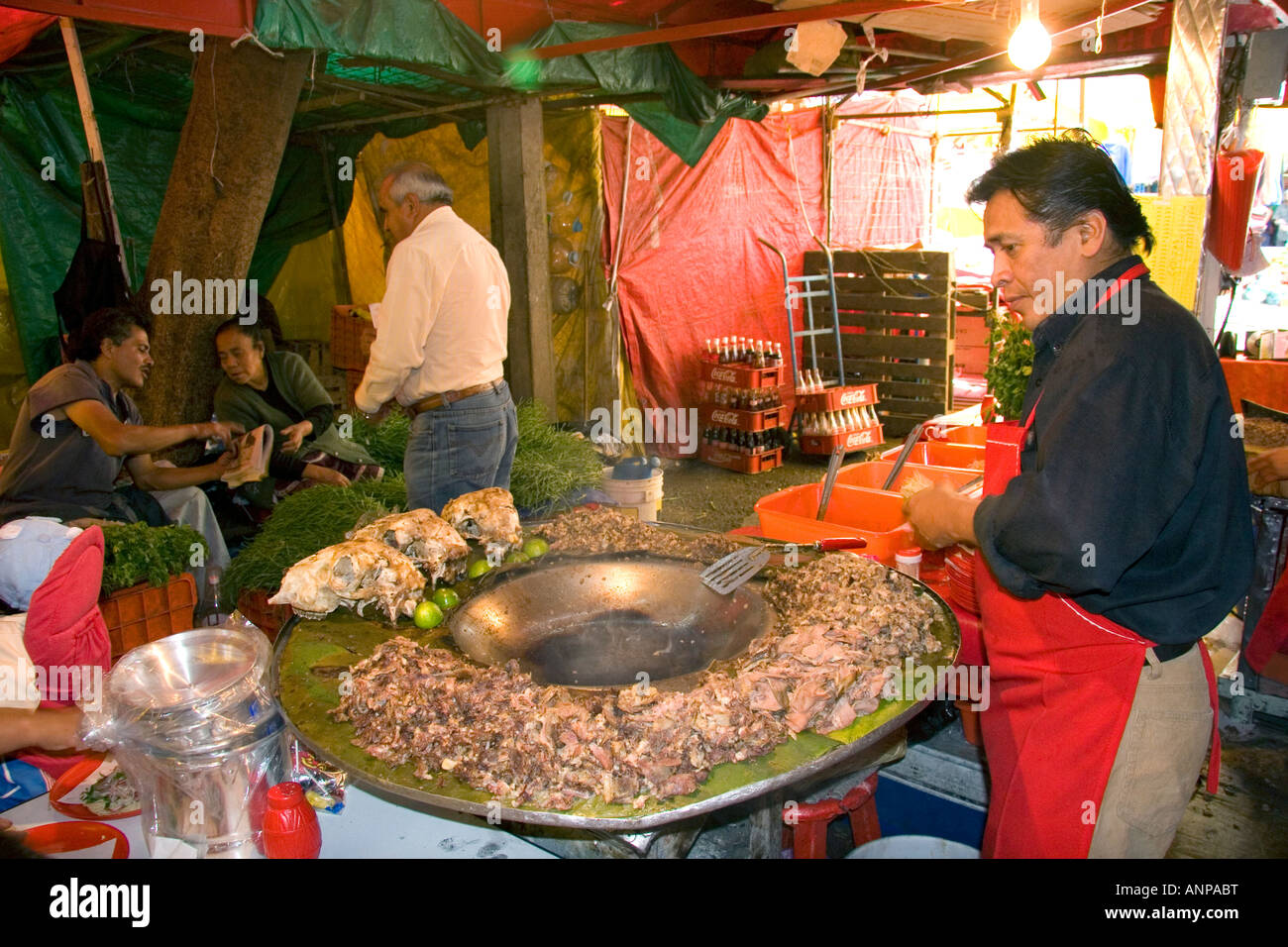 Vendor cooking cabeza tacos using a cazo at the Merced Market in Mexico ...
