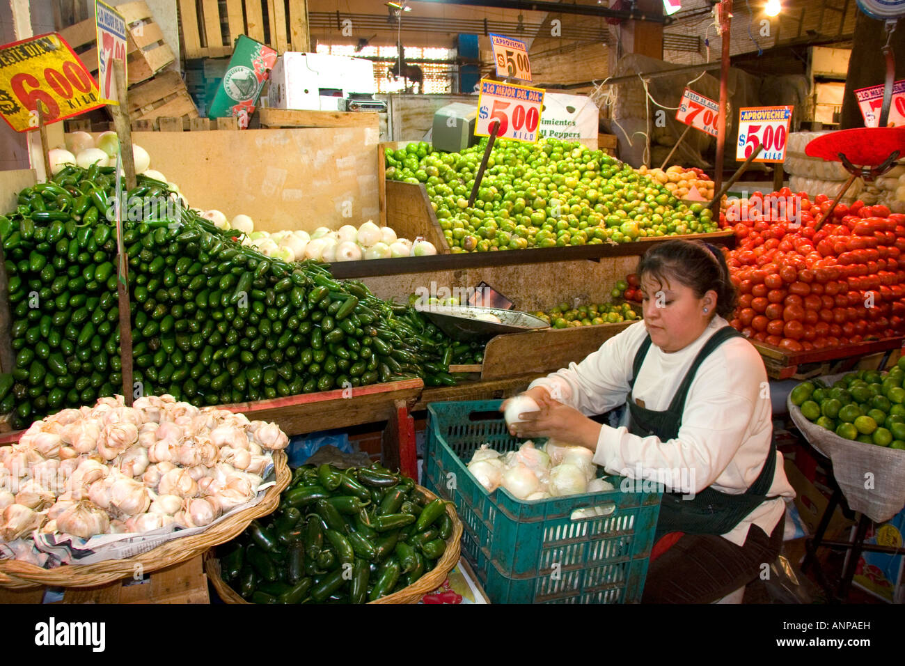 Vendor stocking onions at a produce stand at the Merced Market in ...