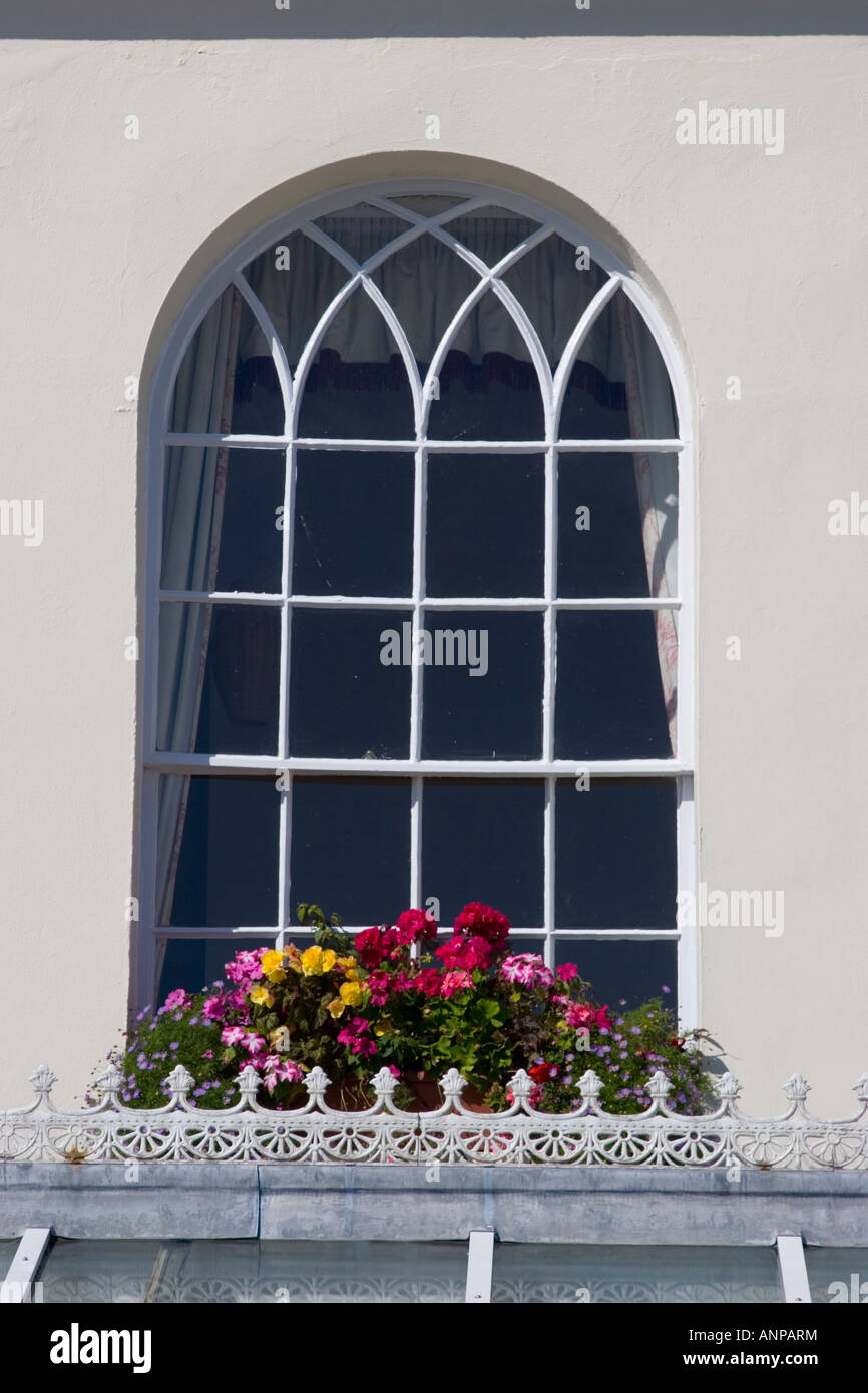 An attractive period window with rounded arch and flowers in a window ...