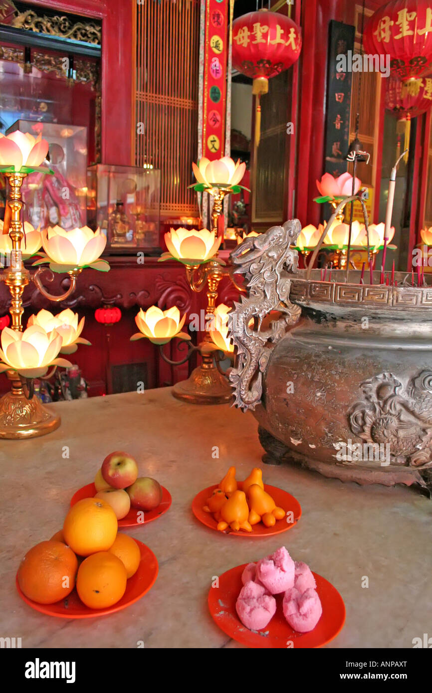 Altar in a chinese temple with various offerings and candles Stock ...
