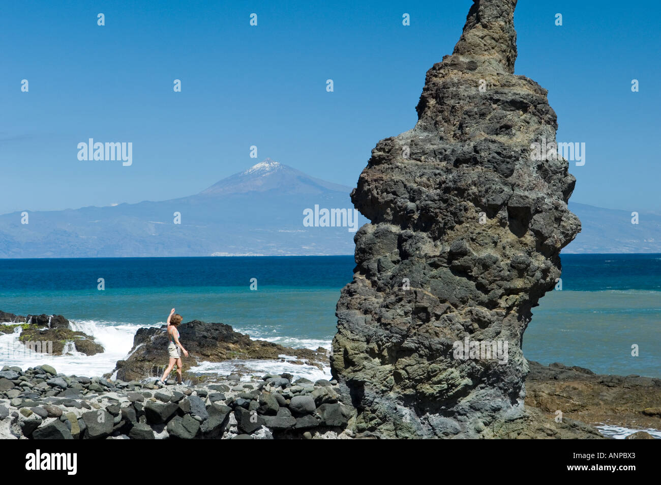 La Gomera, Canary Islands. Woman walking along shore at Playa de La Caleta near Hermigua ...