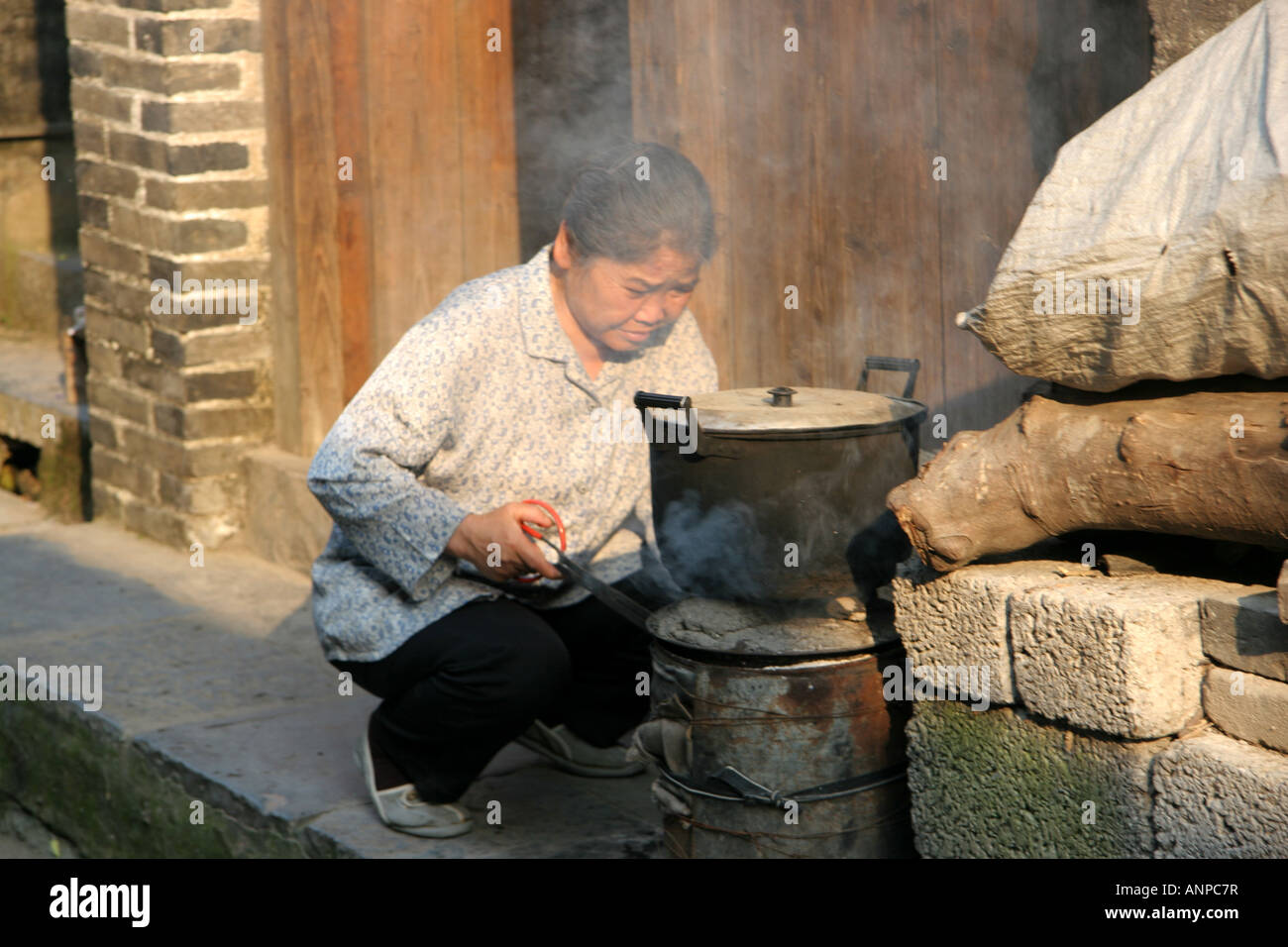 Woman cooking outside in the street in Xingping China Stock Photo - Alamy