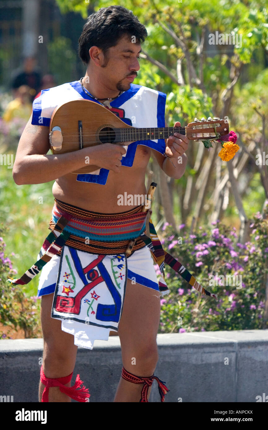 Aztec indian man in traditional dress playing the madolin during a ...