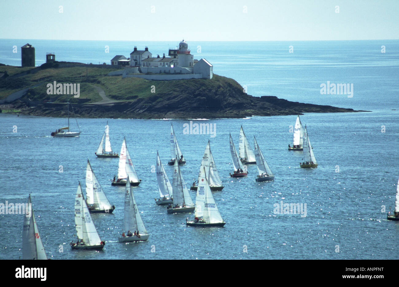Sailing boats racing in front of the lighthouse at Roches Point, Cork ...