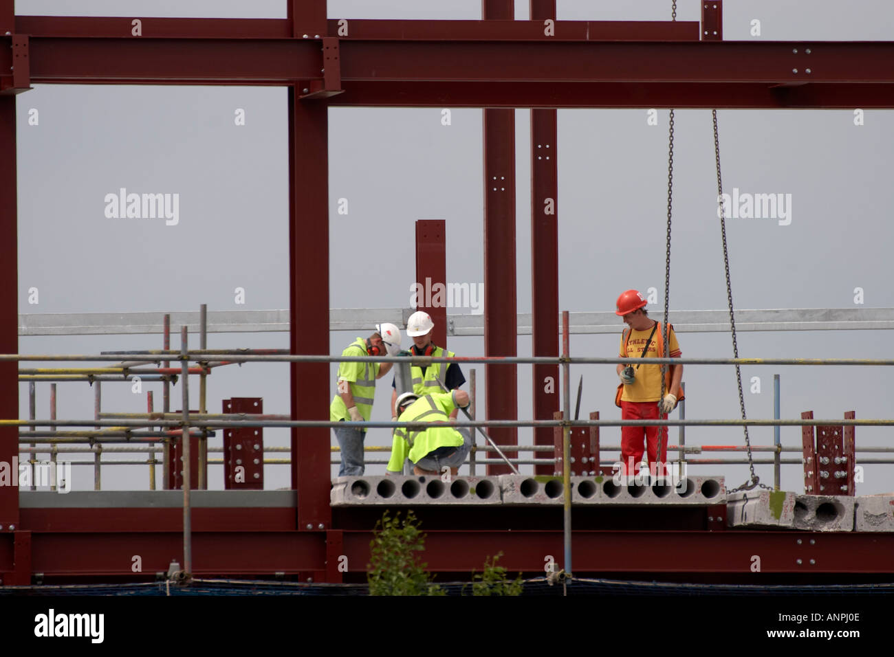 Construction workers moving concrete floor beams into place on a ...