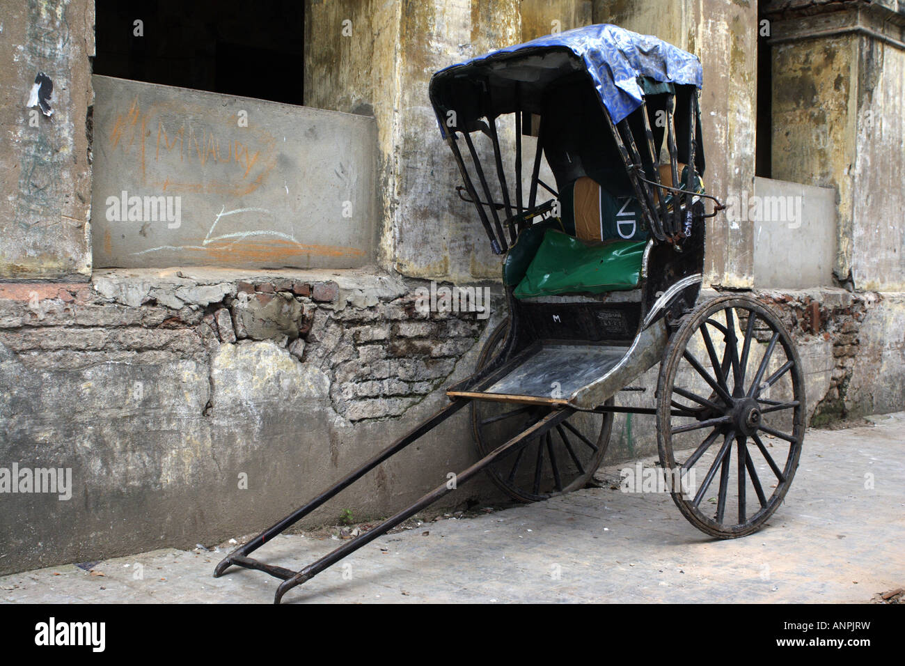 A hand-pulled rickshaw stands unattended in Sudder Street, Kolkata ...