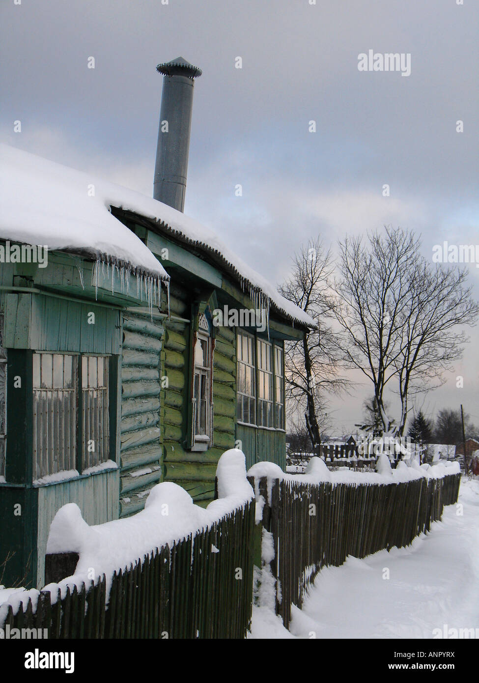 Snow covered with icicles traditional Russian village house with ...