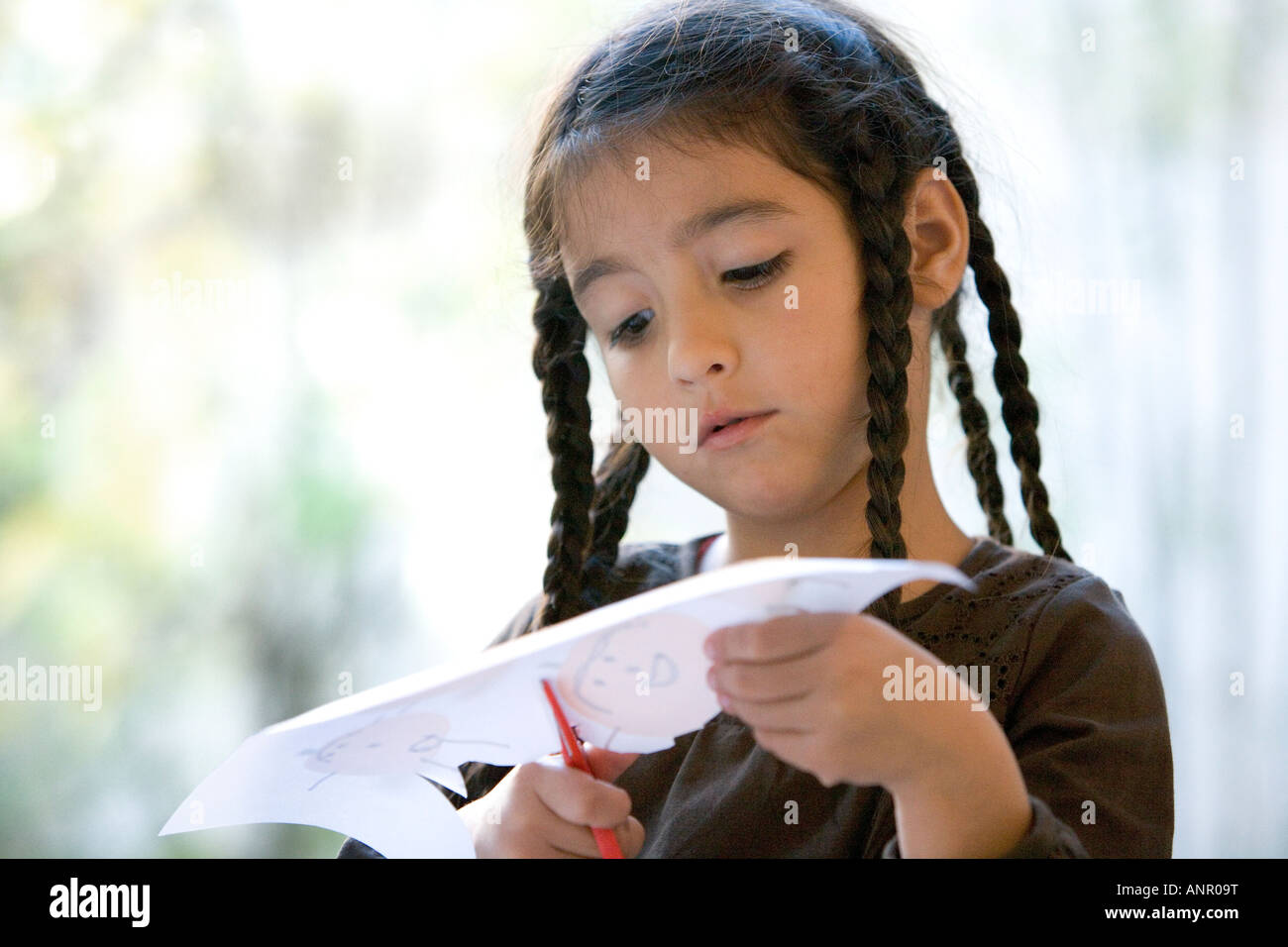 Little girl cutting paper with scissors Stock Photo - Alamy