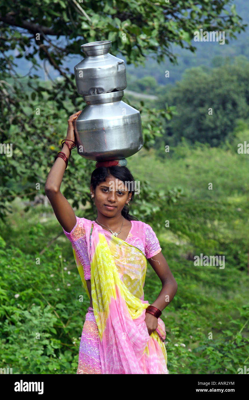 Beautiful Indian girl carrying metallic water containers on her head ...