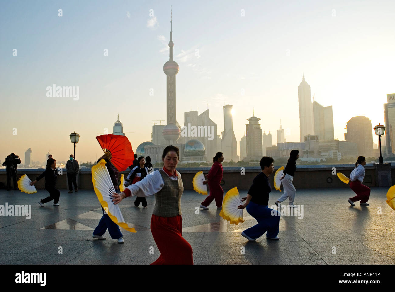 Women team doing morning exercise with fans on the Bund, Shanghai ...