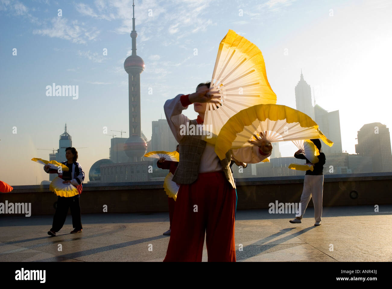 Women team doing morning exercise with fans on the Bund, Shanghai ...