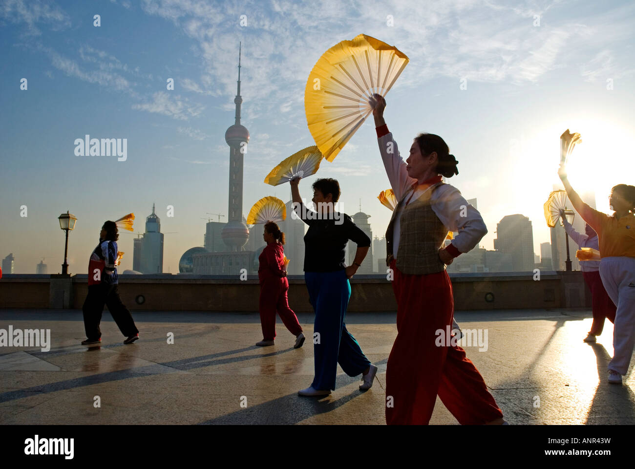 Women team doing morning exercise with fans on the Bund, Shanghai ...