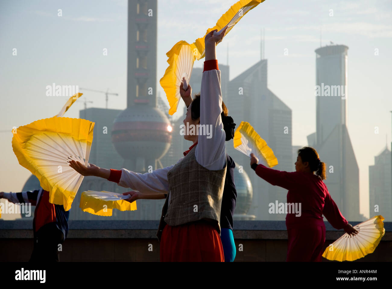 Women team doing morning exercise with fans on the Bund, Shanghai ...