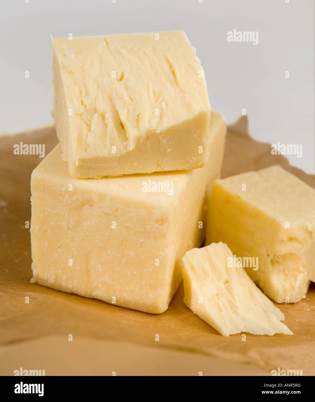 Blocks of mature English Cheeder Cheese shot on a wooden cheeseboard ...