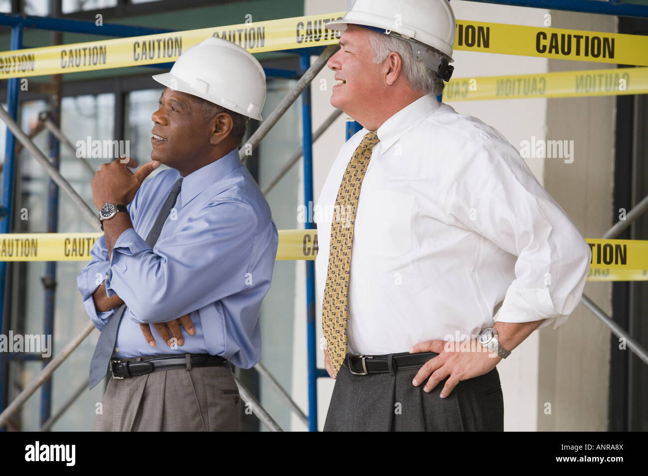 Side profile of two engineers standing in a construction site Stock ...