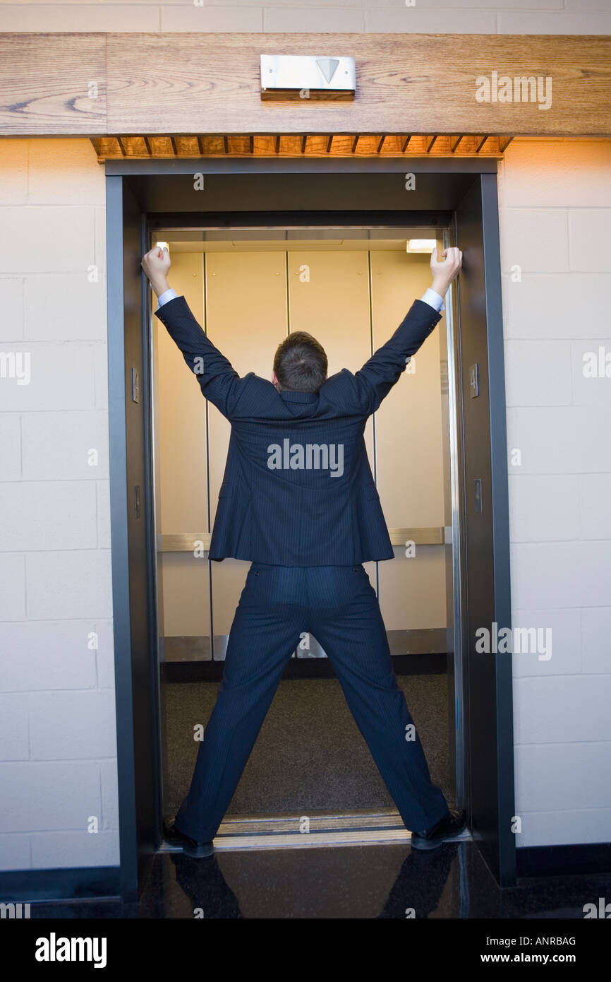 Rear view of a businessman stopping an elevator Stock Photo - Alamy