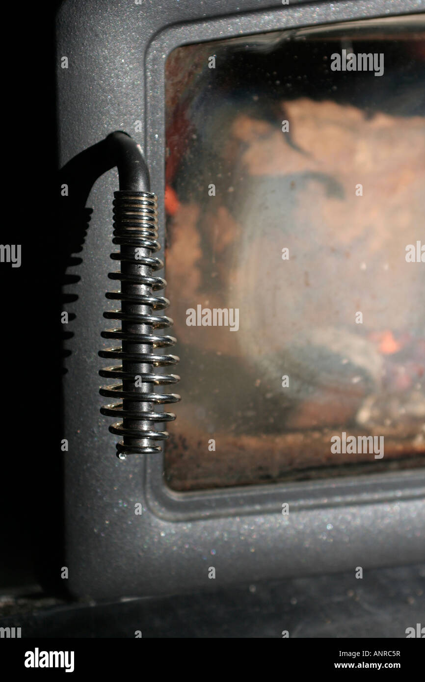 Wire handle on woodstove Stock Photo - Alamy