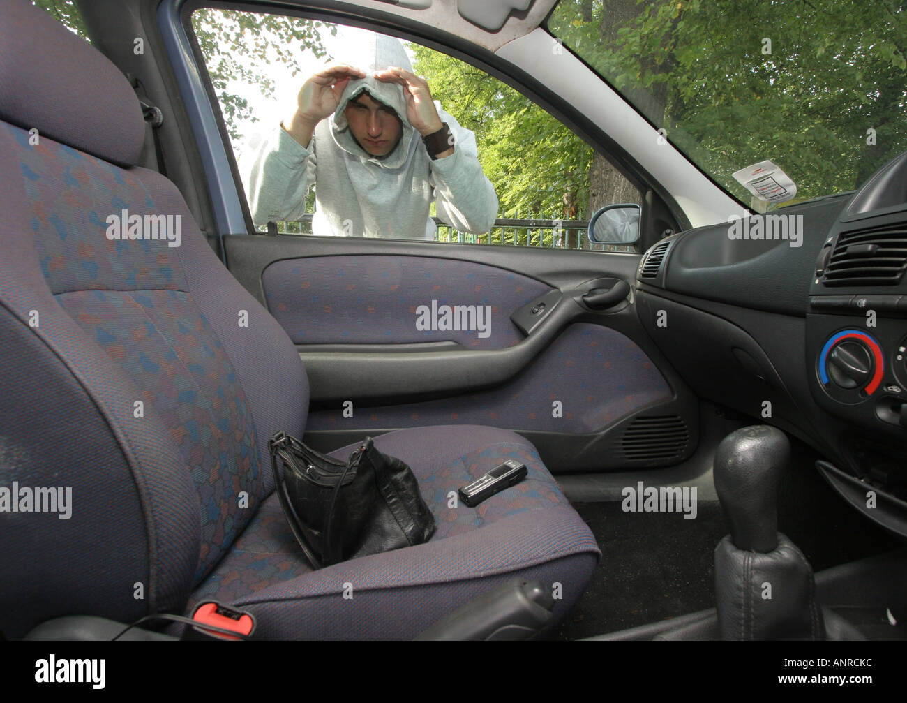 Youth looking through car window Stock Photo - Alamy