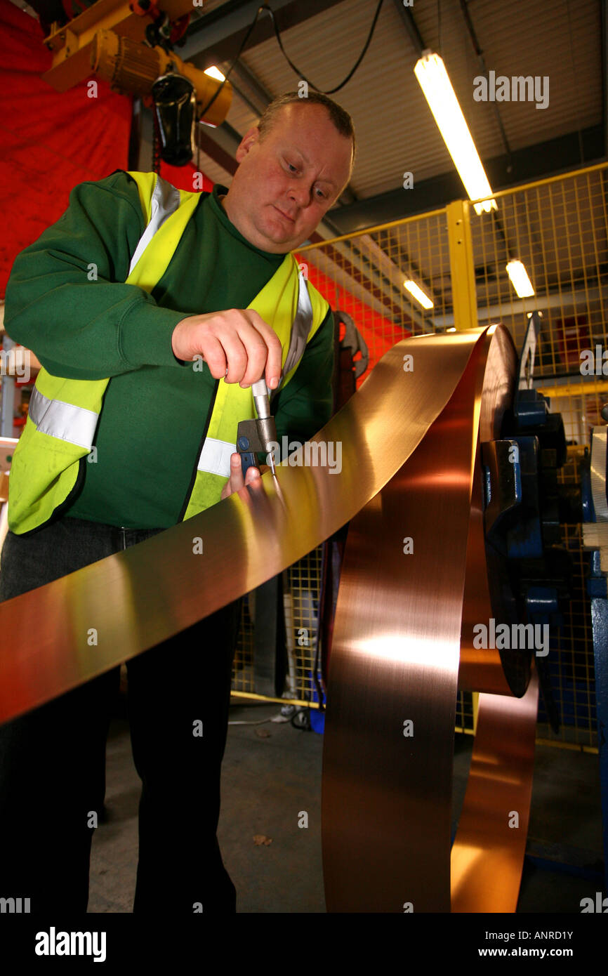 Copper Stripping Coil is measured out by a factory worker Stock Photo ...