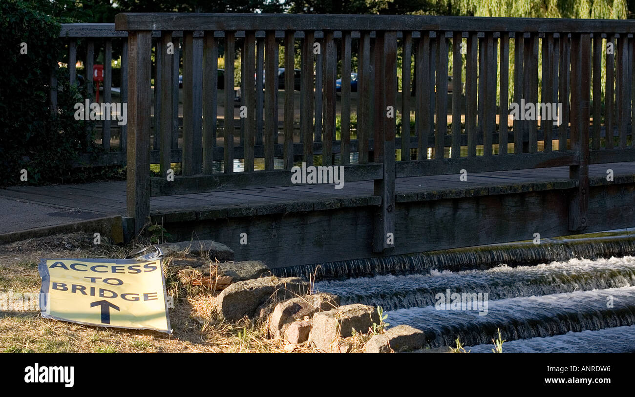 Small waterfall under bridge with sign on the floor Stock Photo - Alamy