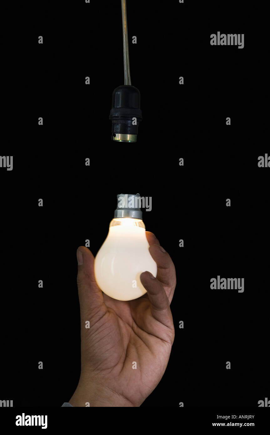 Close-up of a person's hand holding an illuminated light bulb Stock ...